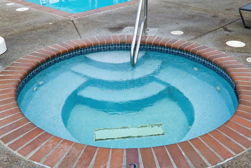 Empty Circular Spa Next To Pool with Red and Blue Tiles Stock Photo ...