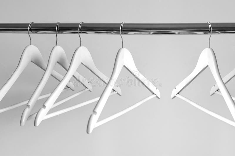 Empty Clothes Hangers on Metal Rail Against Grey Background ...