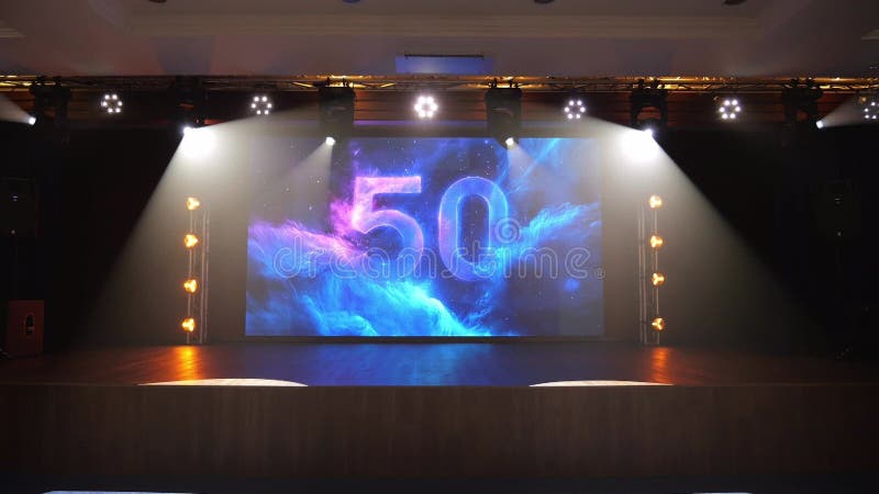 An Empty Concert Stage with a Large Screen with the Number 50 and ...