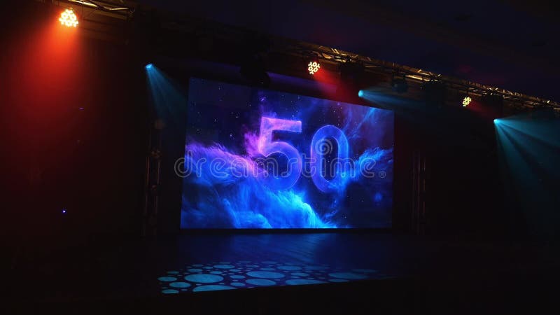 An Empty Concert Stage with a Large Screen with the Number 50 and ...