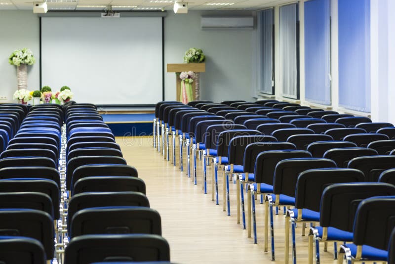 Empty Conference Room with Blue Chairs in Front of Stage with Screen ...