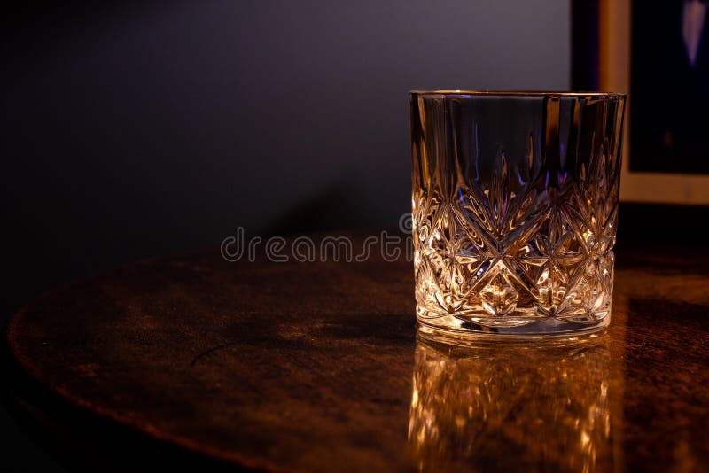 An Empty Crystal Glass Resting on on a Table with a Dark Wood Gr Stock ...