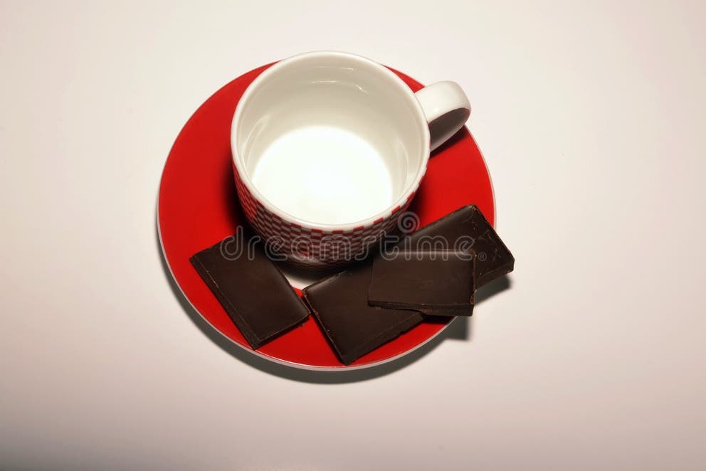 An Empty Tea Cup and Three Pieces of Chocolate on a Red Saucer Stock ...