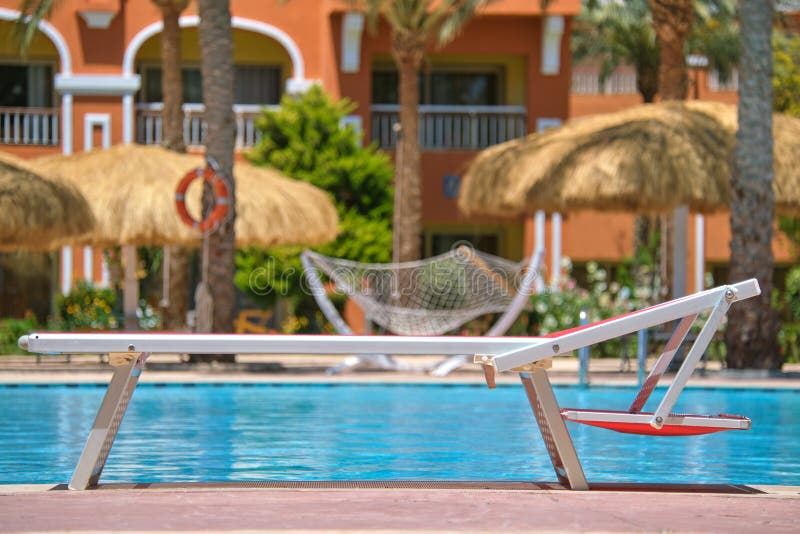 Empty Deck Chair on Swimming Pool Side in Summer Resort. Vacations and ...