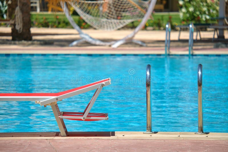 Empty Deck Chairs Under Straw Shade Umbrellas on Swimming Pool Side in ...