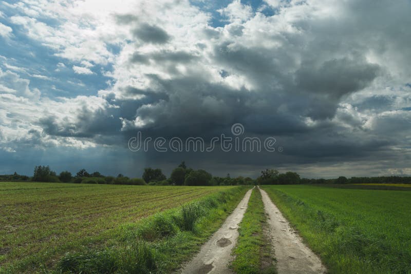 Empty Dirt Road through Fields and a Single Cloud with Rain Stock Image ...