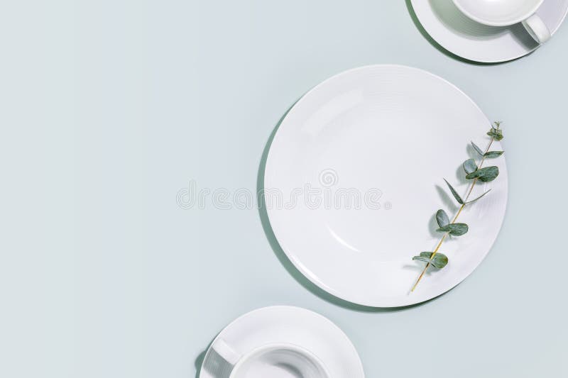 Empty Dishes and Cups with Eucalyptus Twig on Blue Background with Copy ...