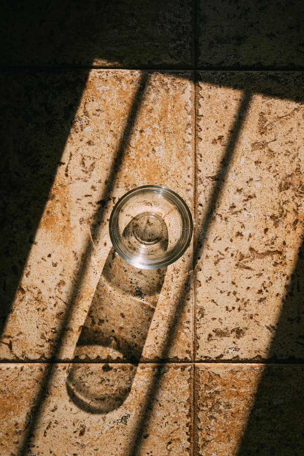 Empty Drinking Glass on the Floor Casting Shadow Stock Image - Image of ...