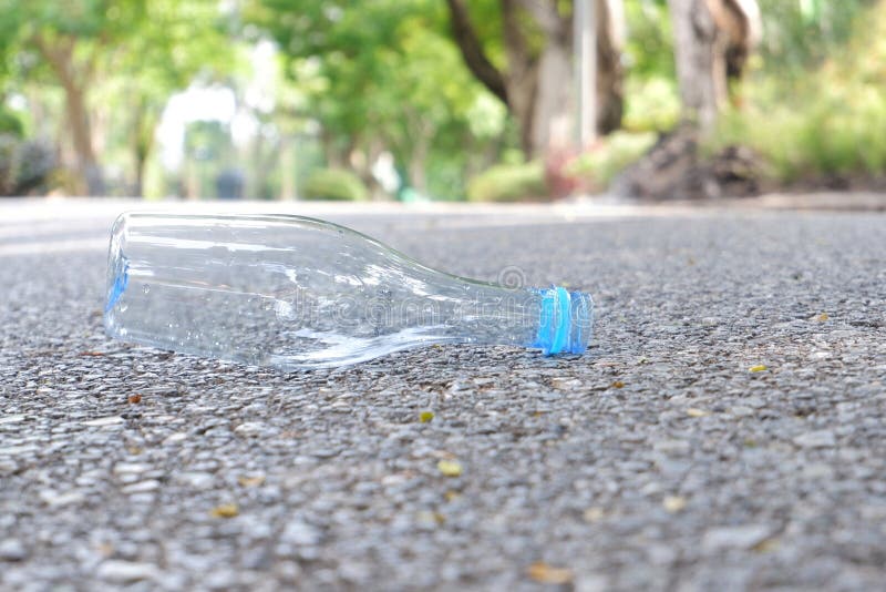 A Plastic Bottle of Drinking Water Littering on Pathway with Green Field Background,for Saving ...