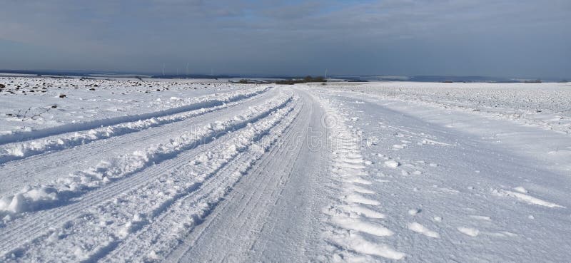 Empty Field Covered by Snow and Tire Tracks on Background of the Cloudy ...