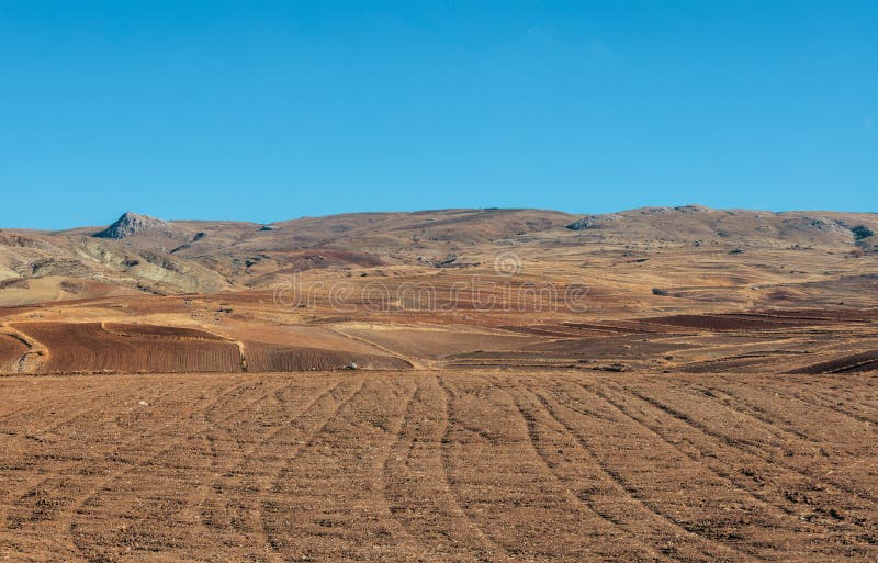 Empty Field in Front of Mountainous Terrain and the Blue Sky in a Sunny ...