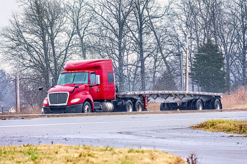 An Empty Flatbed Tractor Trailer Drives in Mixed Winter Weather Stock ...