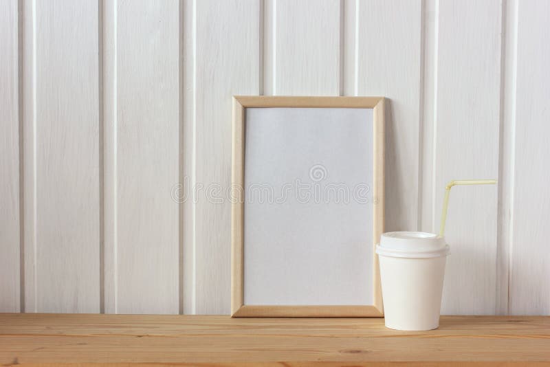 Empty Frame and a Paper Cup on the Table Stock Photo - Image of wall ...