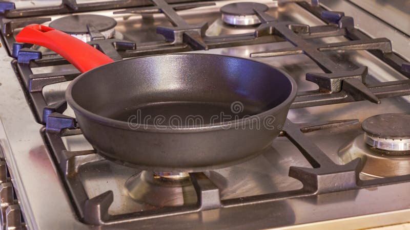 Empty Frying Pan with Red Handle on the Stove Stock Image - Image of ...
