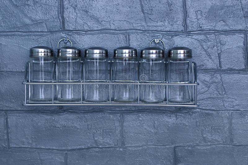 Empty Glass Spice Jars on Gray Brick Kitchen Wall Stock Image - Image ...
