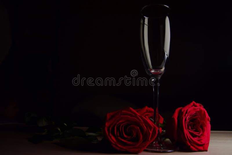 Empty Glass and Three Bright Red Roses on a Black Background Stock ...
