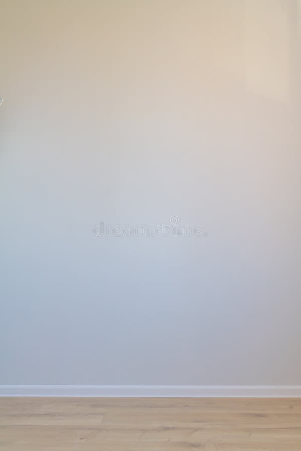 An Empty Gray Wall and a Beige Background with a White Baseboard ...
