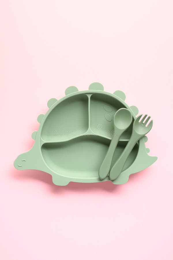 Empty Green Dinosaur-shaped Kids Plate with Utensils on a Pink ...