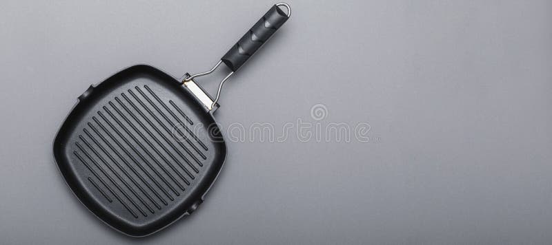 Empty Grill Pan on Home Kitchen Table. Metal Knives on a Grey ...