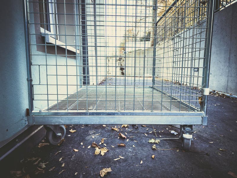 Empty Iron-barred Box on Wheels Outside a Buidling Stock Photo - Image ...