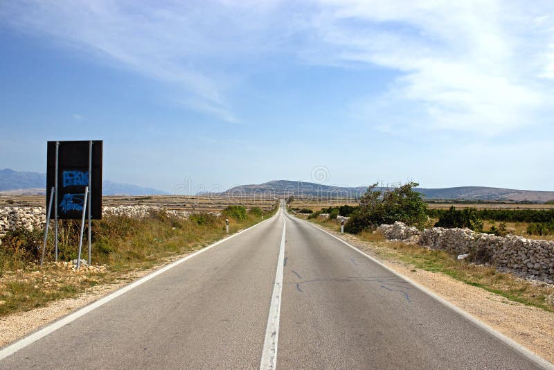 Empty Island Road with Travel Sign and Blue Mountains Stock Photo ...