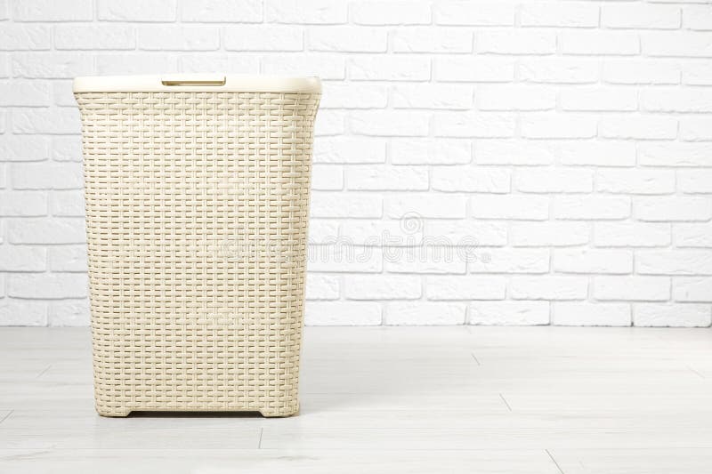 Empty Laundry Basket Near White Brick Wall. Space for Text Stock Photo ...