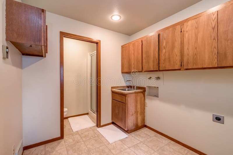 Empty Laundry Room with Wood Cabinets Real Estate Stock Image - Image ...