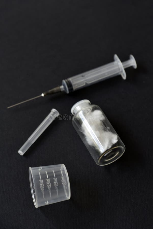 An Empty Medical Syringe and a Glass Bottle on a Black Background Stock ...