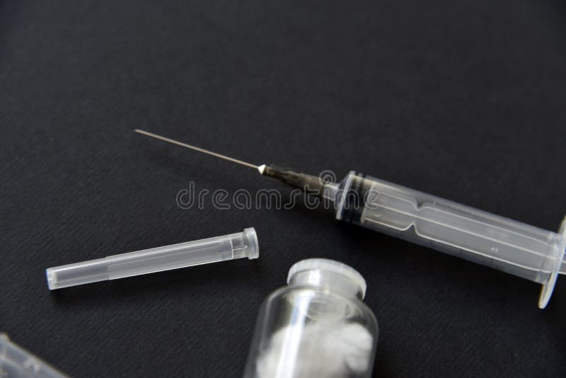 An Empty Medical Syringe and a Glass Bottle on a Black Background Stock ...