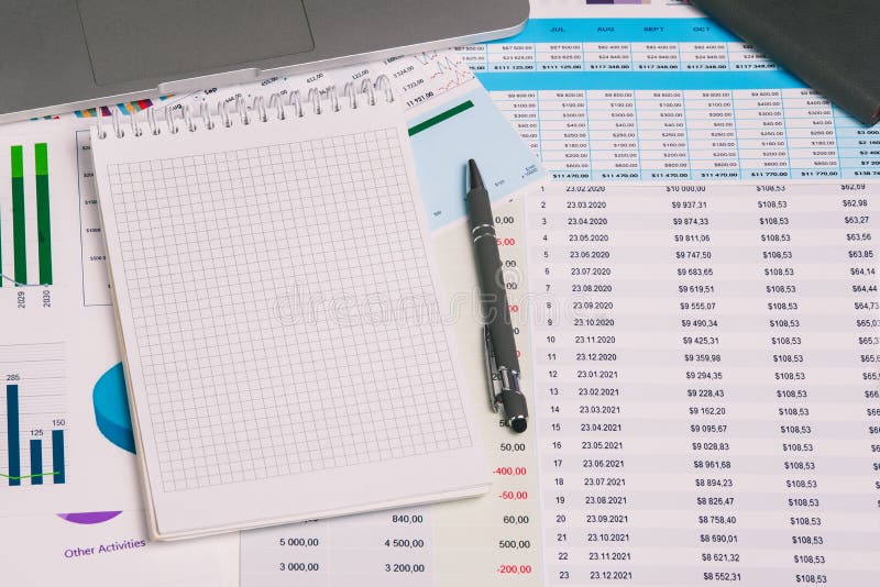 An Empty Notepad with a Pen and Statistical Graphs on the Desktop ...