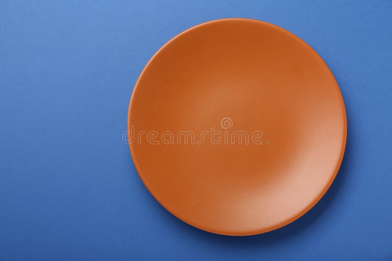 Empty Orange Ceramic Plate on Blue Background, Top View. Space for Text ...