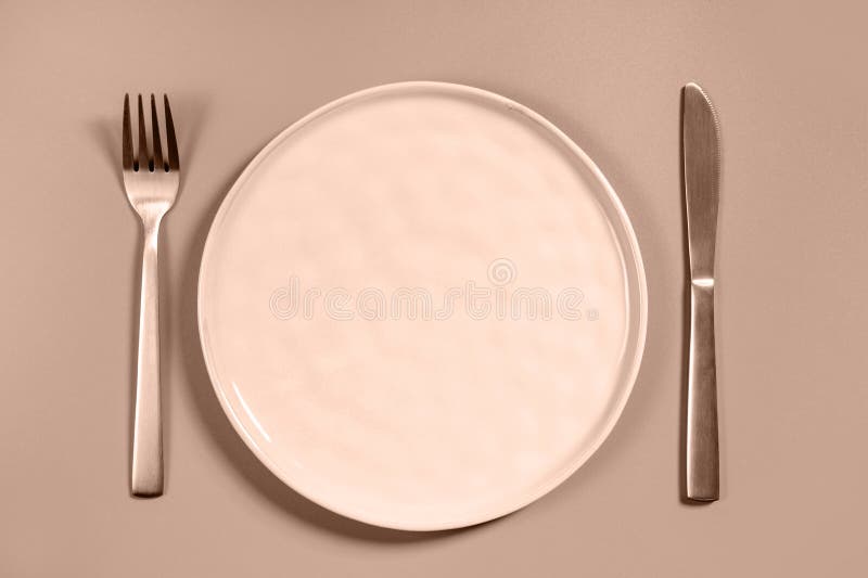 Empty Plate, Fork and Knife in Trending Color of Year 2025. Stock Photo ...