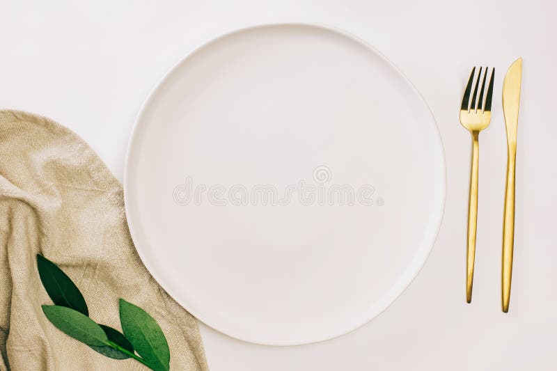 Empty Plate and Golden Cutlery on the White Table. Minimalist Table ...