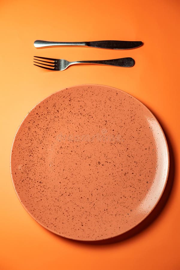 Empty Plate with Knife and Fork on Orange Background Stock Image ...