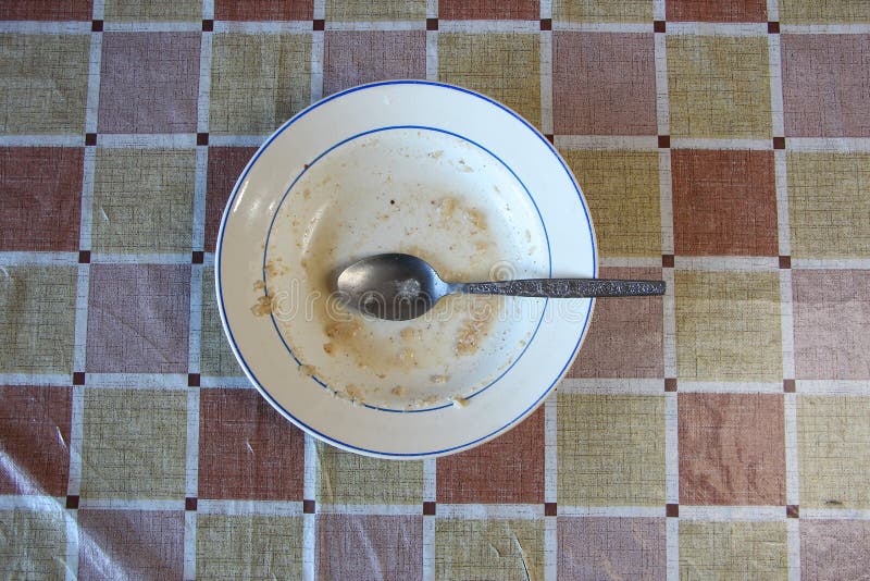 Empty Plate with Leftover Porridge and Spoon on a Table Stock Photo ...