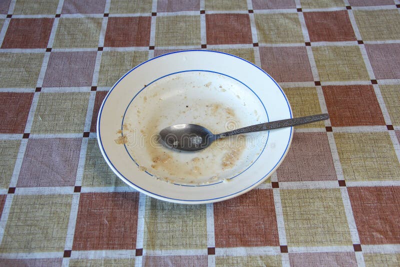 Empty Plate with Leftover Porridge and Spoon on a Table Stock Image ...