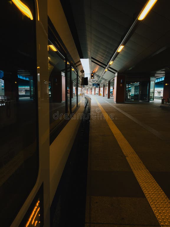 Empty Platform at Central Station Featuring Modern Train Waiting Under Artificial Lights ...