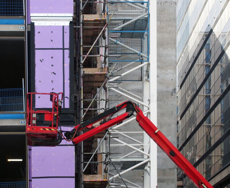 Empty Red Aerial Work Platform on a Large Urban Construction Site with ...