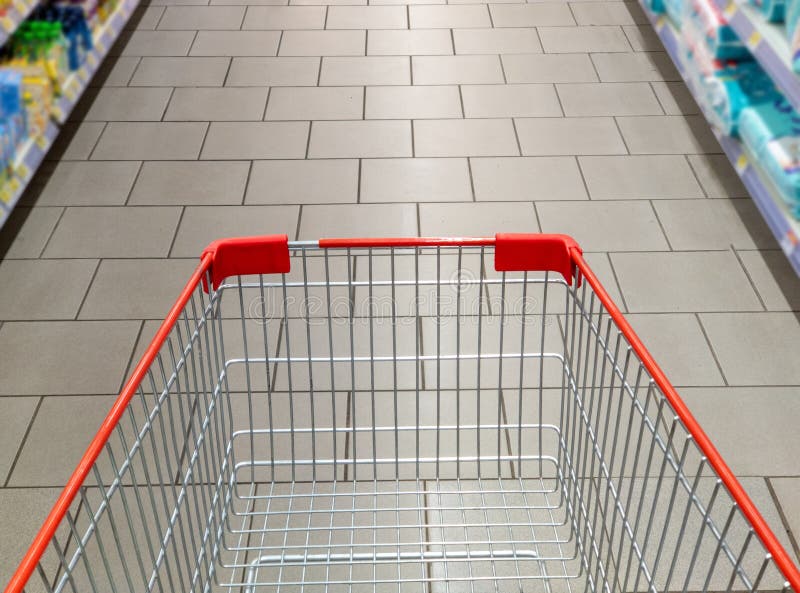 Empty Red Shopping Cart in Supermarket Aisle. Blurred Background of ...