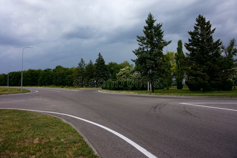 An Empty Road Intersection and Trees Growing Along it in a Gloomy ...