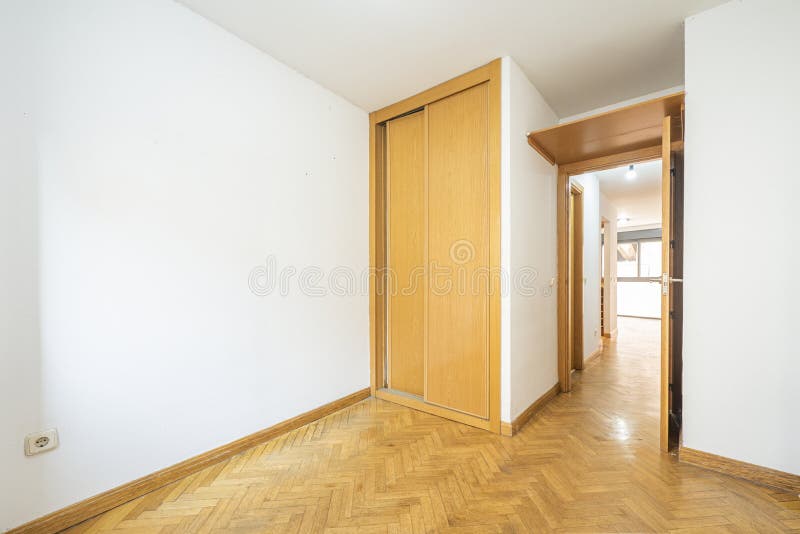An Empty Room with a Built-in Wardrobe with Oak Sliding Doors and ...