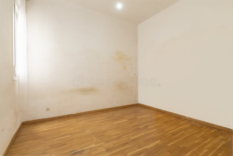 An Empty Room with Walls in Need of a Lick of Paint and Worn Laminated ...