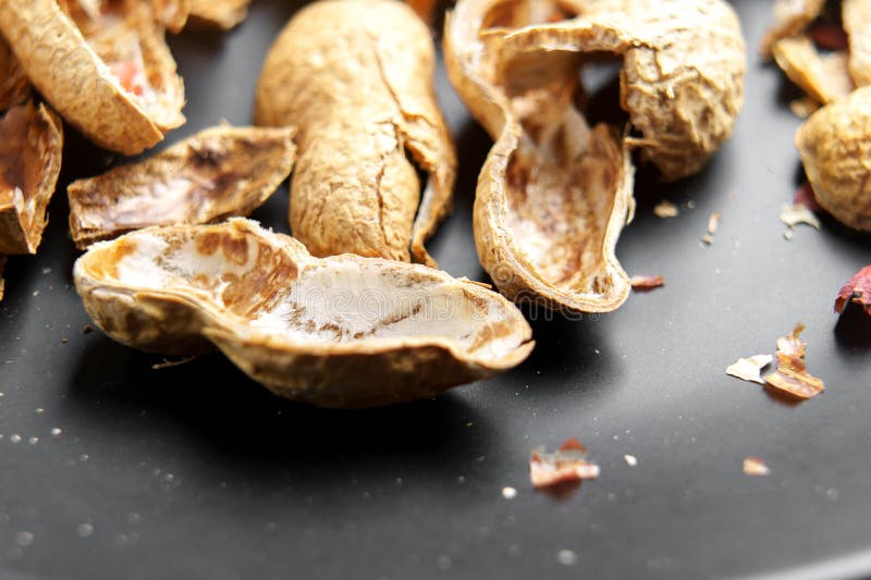 Empty Shells of Roasted Peanuts on Black Ceramic Plate Stock Photo ...