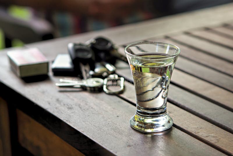 Empty Shot Glass on Table with Matches and Keys in the Background Stock ...