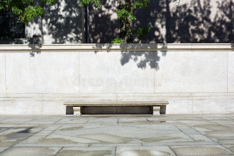 Empty Stone Bench with Light Stone Background and Tree Leaves Stock ...