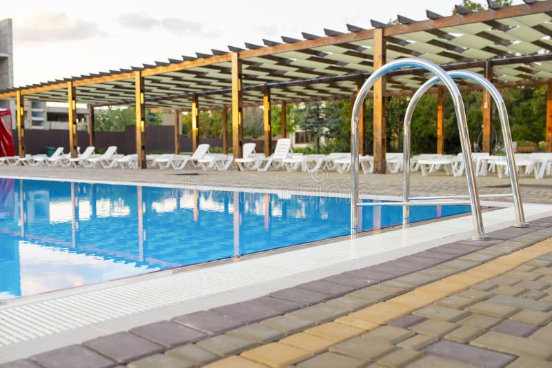 Empty Swimming Pool with Blue Water, Focus on Metal Hand Railing of ...