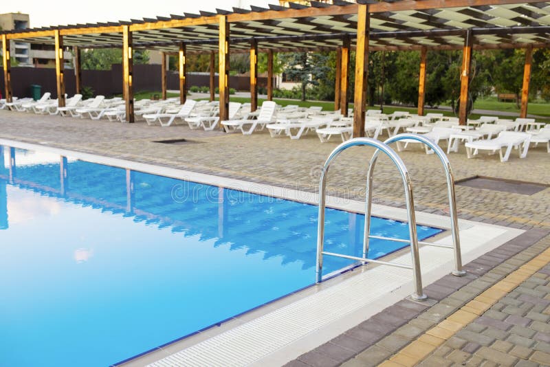Empty Swimming Pool with Blue Water, Focus on Metal Hand Railing of ...