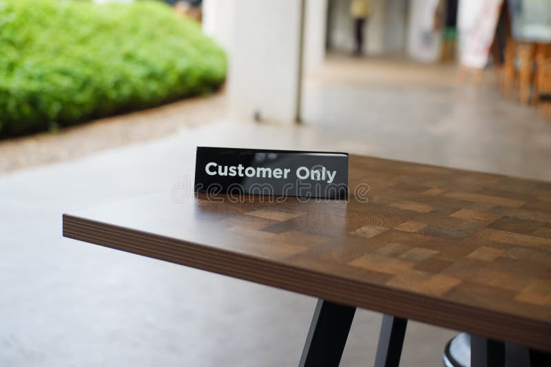 An Empty Table in a Cafe with a Sign for Customers only Stock ...
