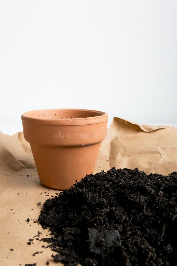 Empty Terracotta Pot with Soil on Craft Paper Against White Background ...