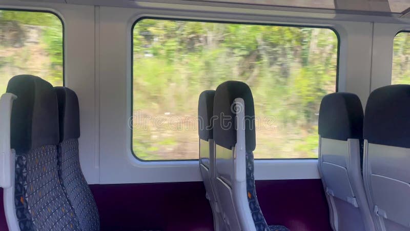 Empty Train Seats Facing Wide Windows with a Scenic View of the English ...